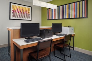 Área de trabalho com dois monitores, um computador desktop e uma impressora sobre a mesa.