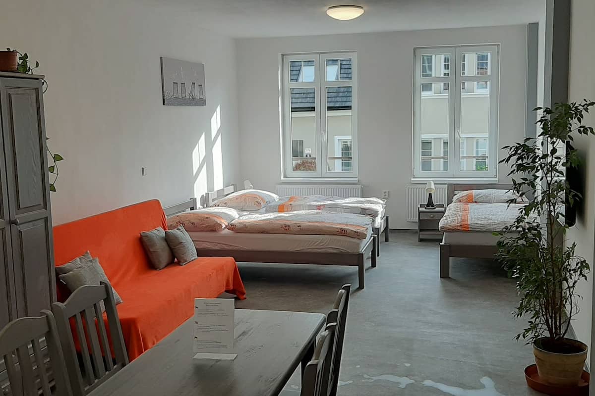 Um quarto com cama, sofá, mesa e armário.