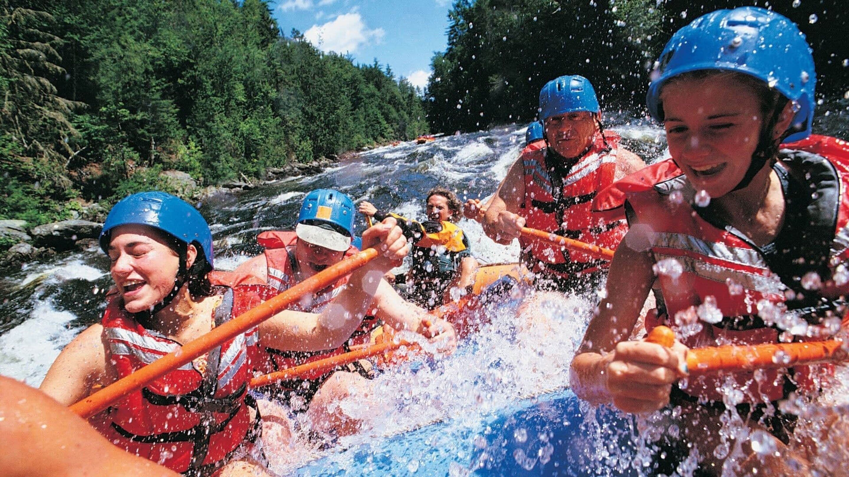 Um grupo de pessoas faz rafting em um rio, cercado por mata densa.