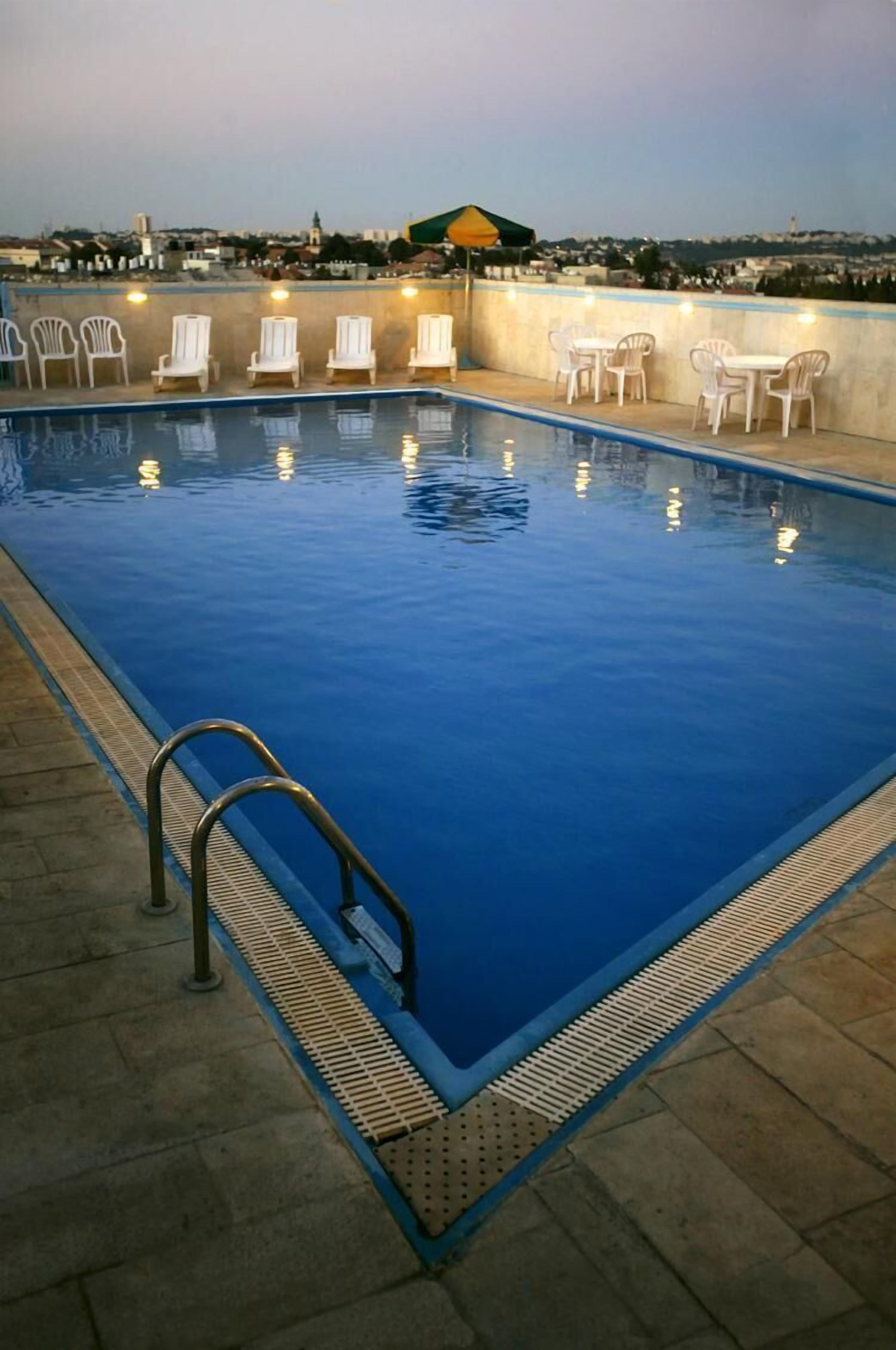 Piscina no terraço com vista desimpedida da paisagem urbana.