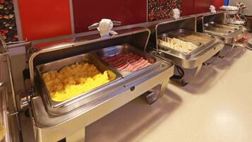 Buffet com diversas opções de comida, incluindo arroz, cachorros-quentes e outros pratos.