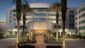 Hotel Intercontinental em Doral, Miami, com design moderno, palmeiras e bandeiras americanas.