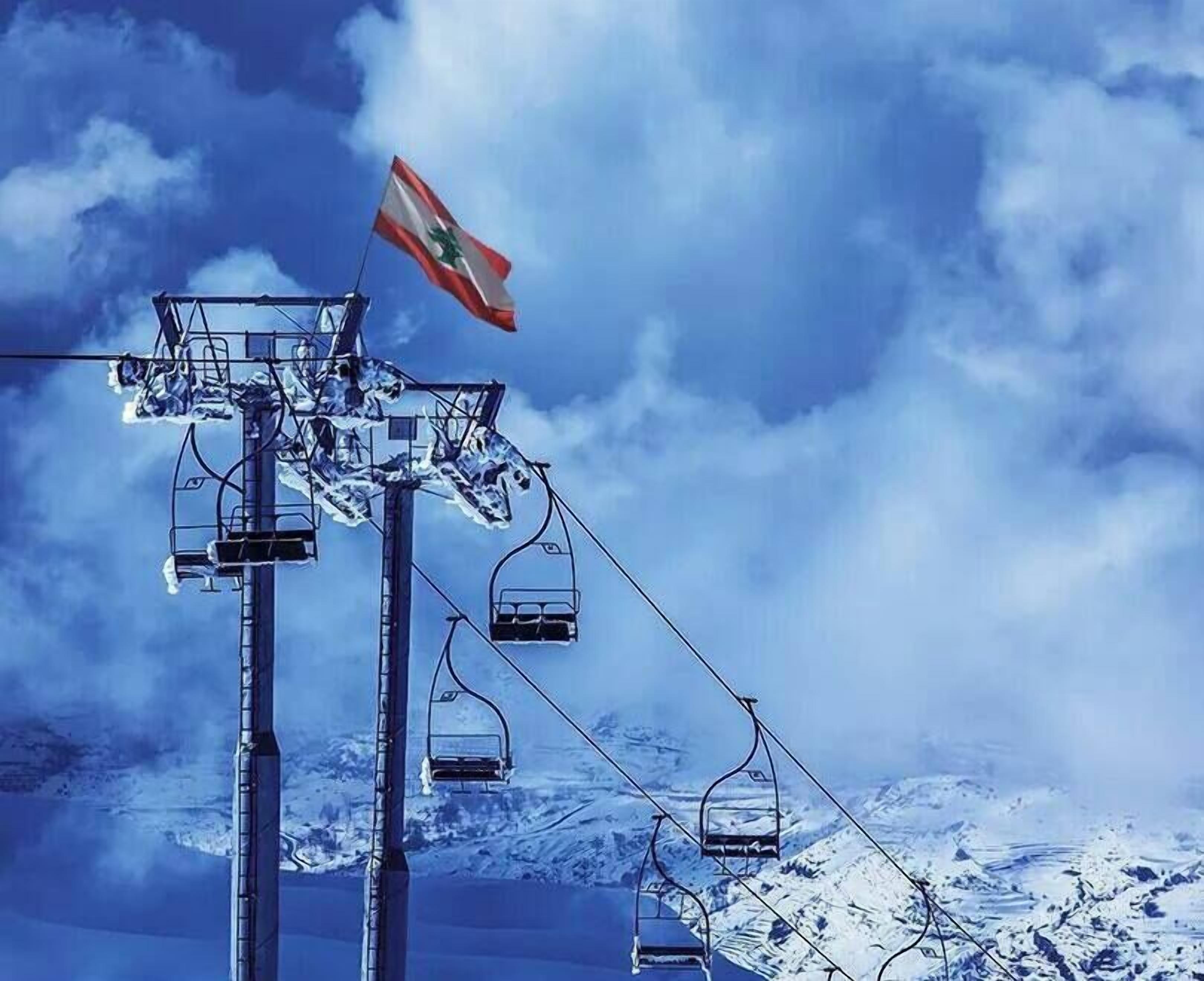 Gondola de esqui com cadeiras e uma bandeira, com montanhas nevadas ao fundo.
