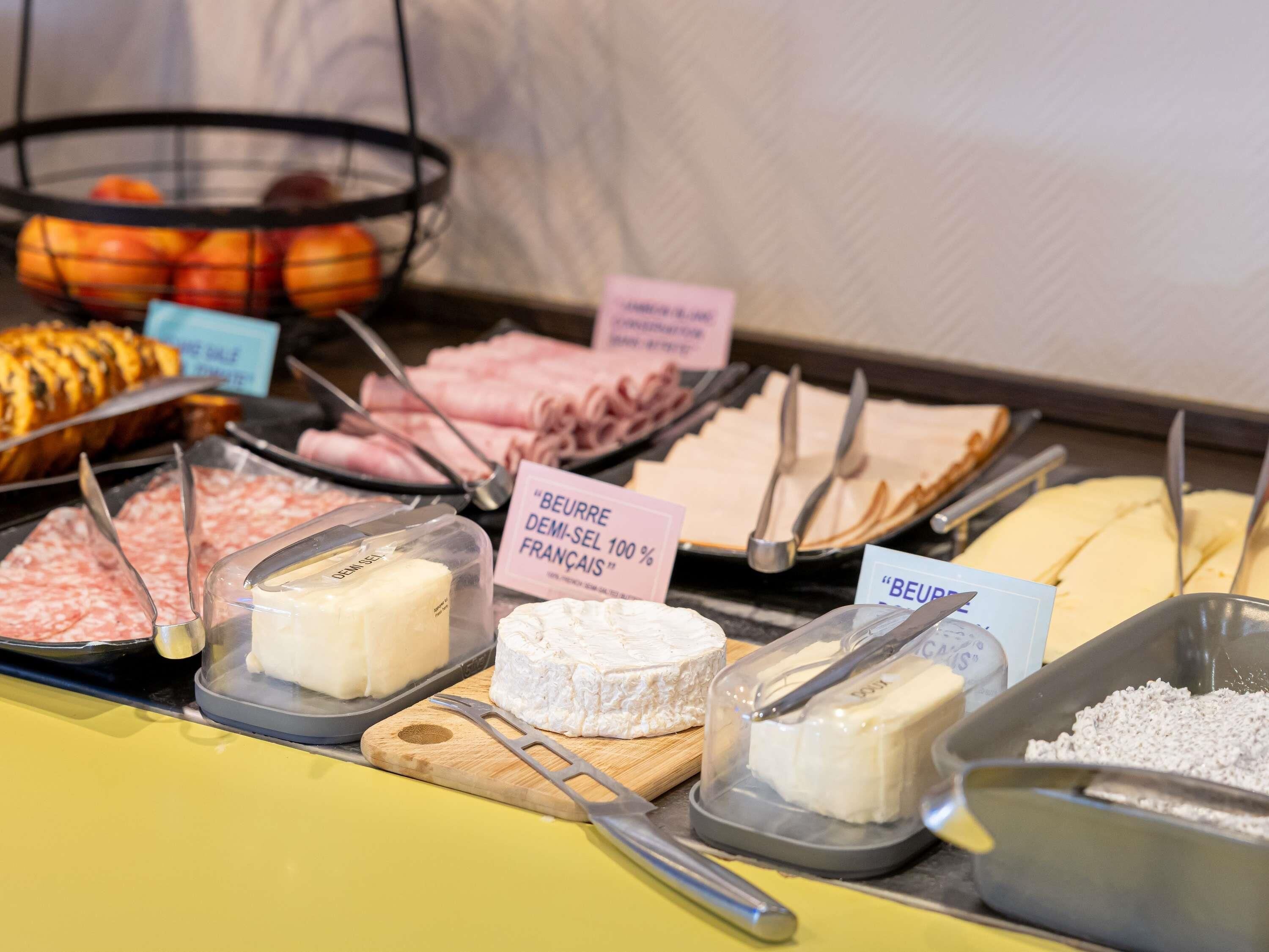 Exposição de queijos e carnes, com etiquetas que indicam origem francesa.