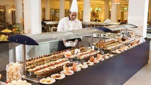Um buffet com diversas sobremesas e frutas.