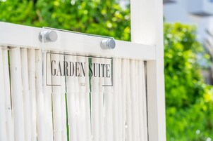 Um portão branco com uma placa que diz 'GARDEN SUITE 302'.