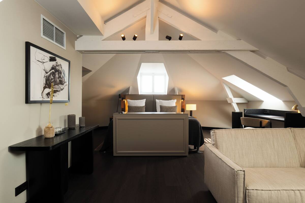 Quarto estilo loft moderno com uma cama grande, uma escrivaninha e um sofá.