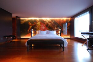Quarto moderno com uma cama grande, uma escrivaninha e uma janela ampla.