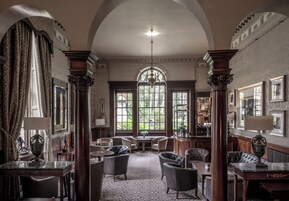 Um quarto espaçoso com teto alto, janelas grandes e um espaço para bar.