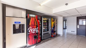 Máquinas de venda automática com marca Coca-Cola e aviso para não encher recipientes de gelo.