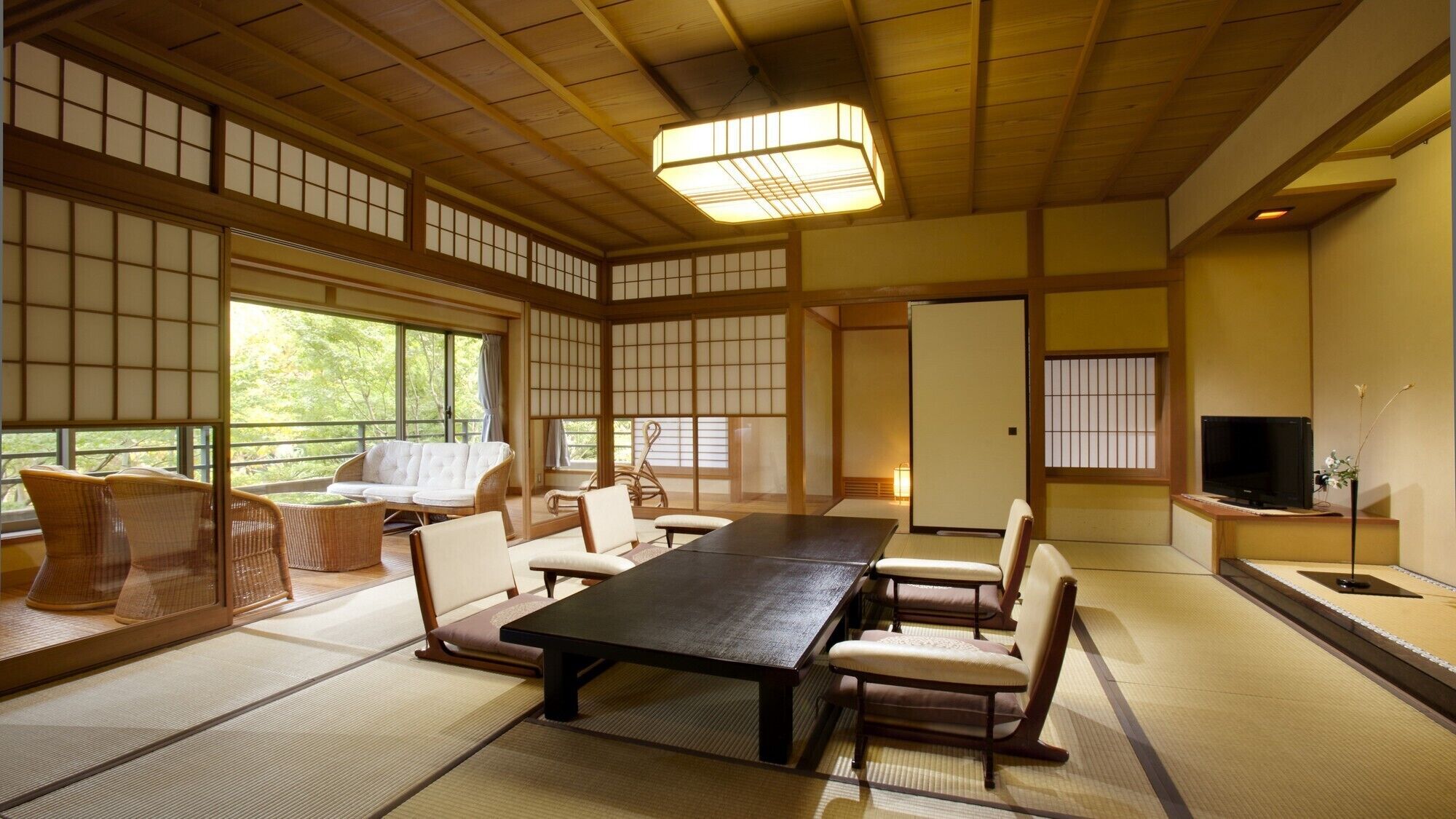 Um quarto tradicional japonês com tatames, uma mesa baixa e assentos.