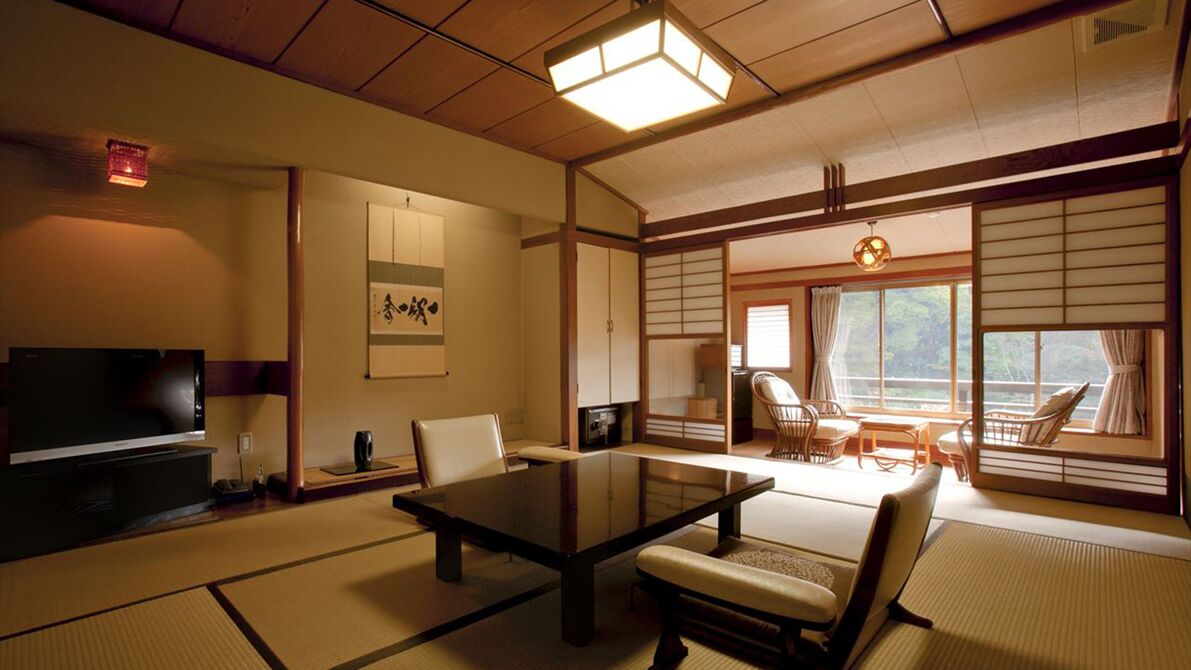 Um quarto em estilo japonês tradicional, com tatames, uma mesa baixa e portas deslizantes.