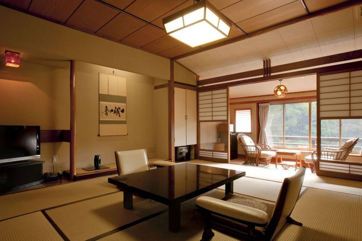 Um quarto em estilo japonês tradicional, com tatames, uma mesa baixa e portas deslizantes.