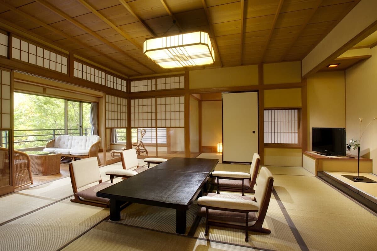 Um quarto tradicional japonês com tatames, uma mesa baixa e disposição de assentos.