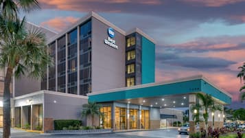 Hotel com fachada moderna, destaque para a placa Best Western e área de entrada coberta.