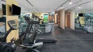 Uma academia com esteiras, elípticos e bicicletas ergométricas.