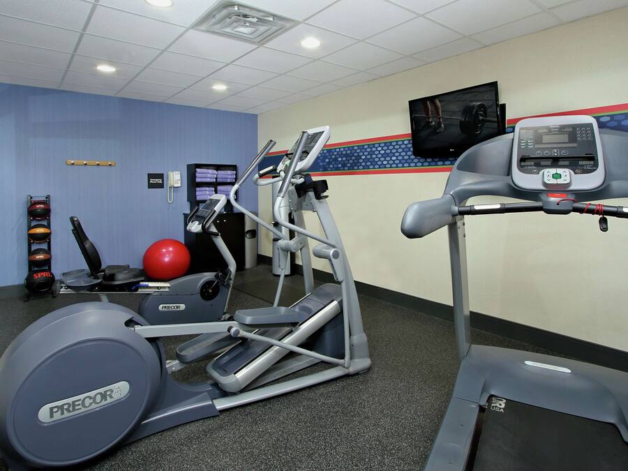 Academia com esteira, elíptico e bolas de exercício.