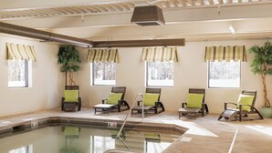 Uma área de piscina com espreguiçadeiras e plantas em vasos.