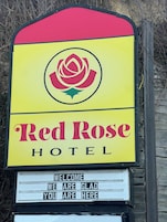 Placa de hotel com um logotipo de rosa vermelha e o nome 'Red Rose Hotel'.