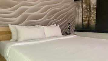 Quarto moderno com uma cabeceira ondulada original, cama bem arrumada com roupa de cama branca e janela vista para uma floresta.