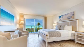 Quarto de hotel com varanda, cama, secretária e cadeira.