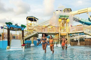 Um parque aquático com um toboágua, piscina e área de recreação.