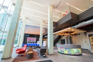 Um lobby moderno com balcão de recepção, área de estar e escada.