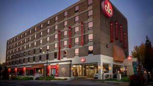 Um hotel com um logotipo vermelho bem visível, várias janelas e banners vermelhos.
