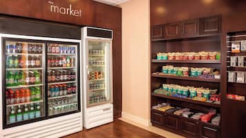 Exposição refrigerada de bebidas e prateleiras com lanches em uma loja.