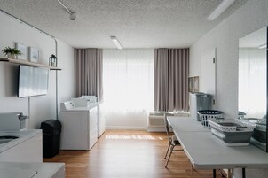 Uma lavanderia moderna com máquina de lavar, secadora e espaço para passar roupa.