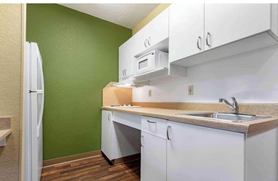 Um frigorífico/congelador grande, um micro-ondas, uma placa de cozinha 