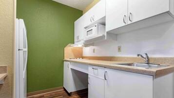 Um frigorífico/congelador grande, um micro-ondas, uma placa de cozinha