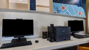 Uma mesa com dois monitores, teclado, rato e impressora.