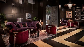 Um interior moderno com piso xadrez, assentos confortáveis e uma parede decorativa com uma obra de arte emoldurada.
