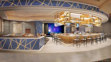Um lobby moderno de hotel com área de bar central, disposição de assentos e palco para apresentações.