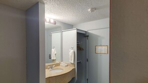 Casa de banho com lavatório, espelho e porta-toalhas.