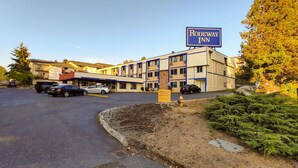 Um motel com uma placa indicando "RODEWAY INN" e um estacionamento cheio de carros.