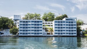 Um hotel à beira-mar com vários andares, varandas e vista para a água.