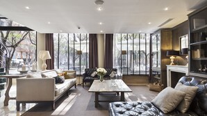 Uma sala de estar moderna com um sofá, um sofá de couro, uma mesa de centro e uma lareira.