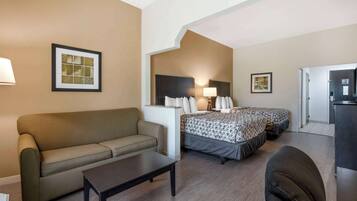 Quarto de hotel com sofá, cama com colcha estampada, escrivaninha e cadeira.