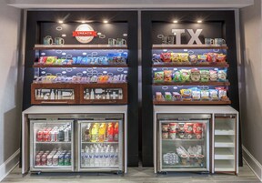 Exposição de lanches com diversos produtos embalados e uma seção refrigerada com bebidas.