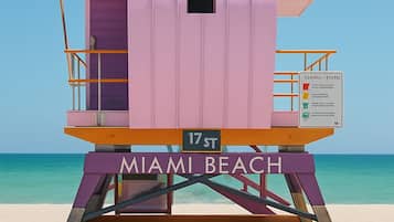 Na praia, espreguiçadeiras, guarda-sóis de praia, toalhas de praia