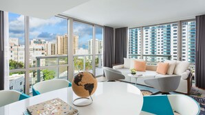 Quarto de hotel moderno com uma grande janela, um globo e um livro intitulado 'Beaches'.