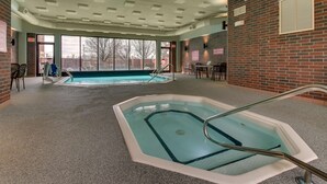 Piscina interna com vista ampla para o exterior através de grandes janelas.