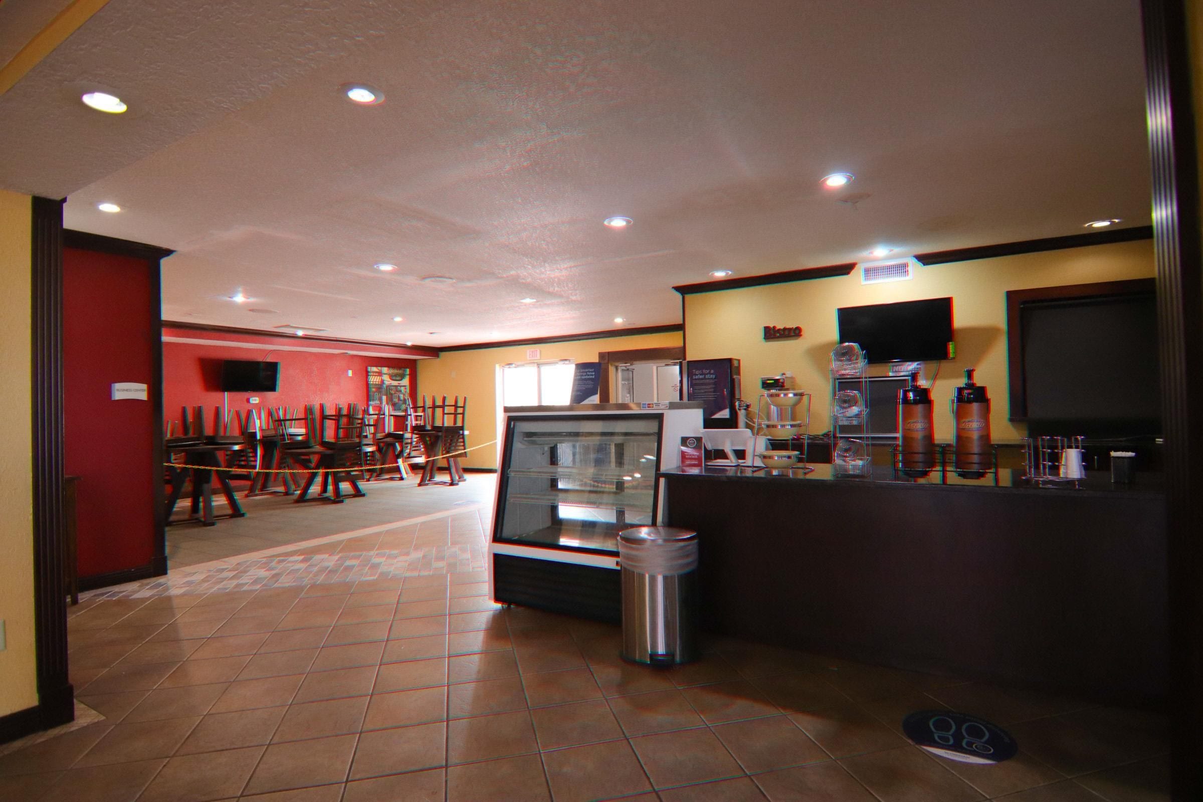 Restaurante com balcão, cadeiras e lixeira.