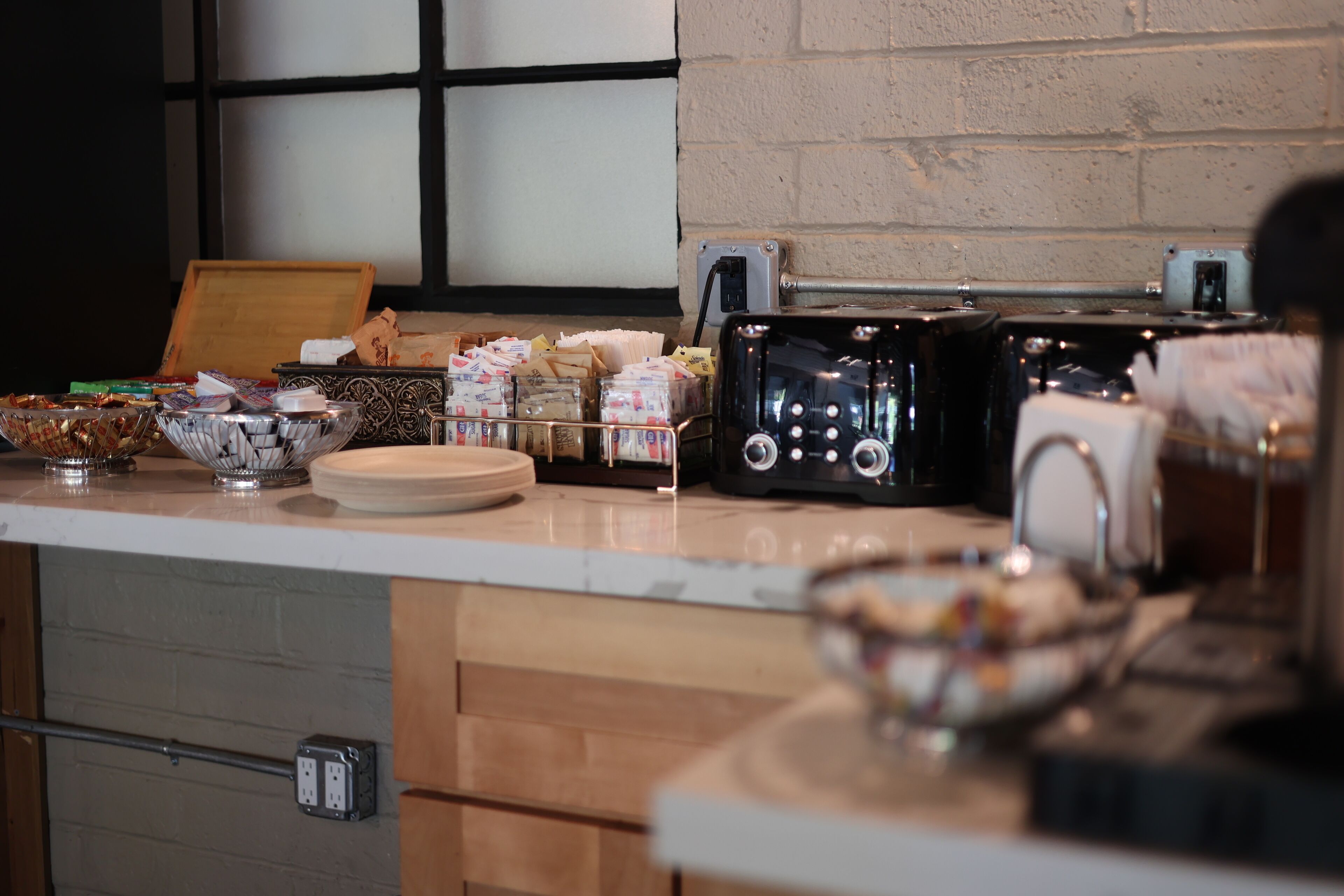 Uma bancada de cozinha com diversos alimentos e eletrodomésticos, incluindo uma torradeira e uma cafeteira.