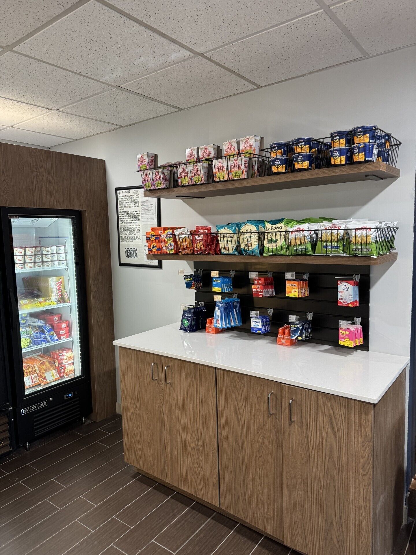 Espaço de lanches e bebidas com serviço próprio, com produtos refrigerados e prateleiras repletas de diversas opções de lanches e bebidas.