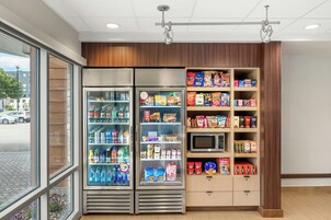 Espaço com máquinas de venda automática de lanches, bebidas e um micro-ondas.