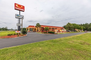 Um motel com telhado vermelho e uma placa indicando 'Econo Lodge'.