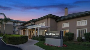 Um hotel com uma placa indicando 'Residence Inn by Marriott', entrada coberta e um gramado bem cuidado.